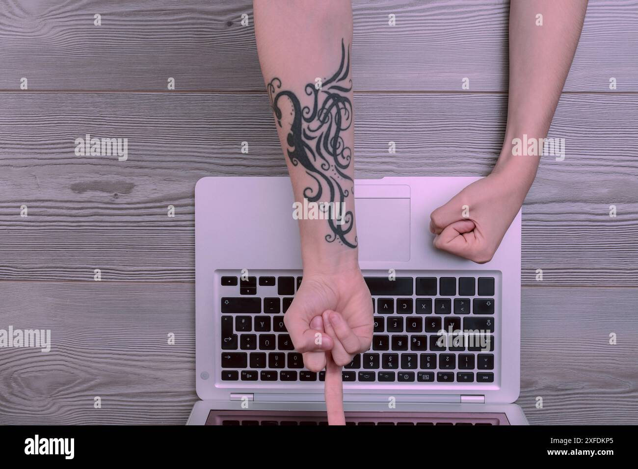 Two hands, one tattooed, are poised in frustration or triumphant ...