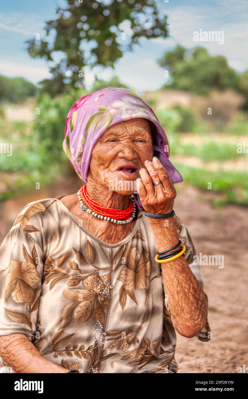 old basarwa woman sitting on the sand in the bush Stock Photo - Alamy