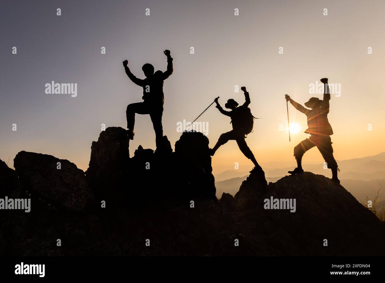 silhouette male and female hikers climbing up mountain cliff . helps ...