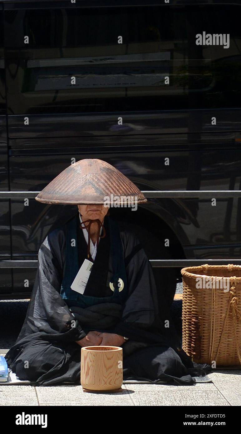A Japanese Zen monk collecting alms on a main commercial street in ...
