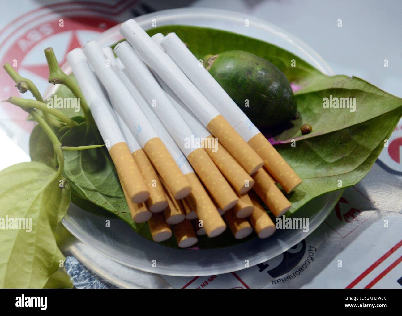 A table with cigarettes offered as good luck gifts and charms outside a ...