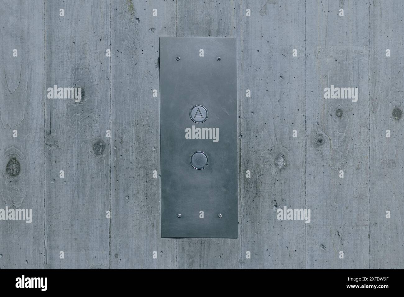 Button of a passenger lift or elevator on interesting concrete wall ...