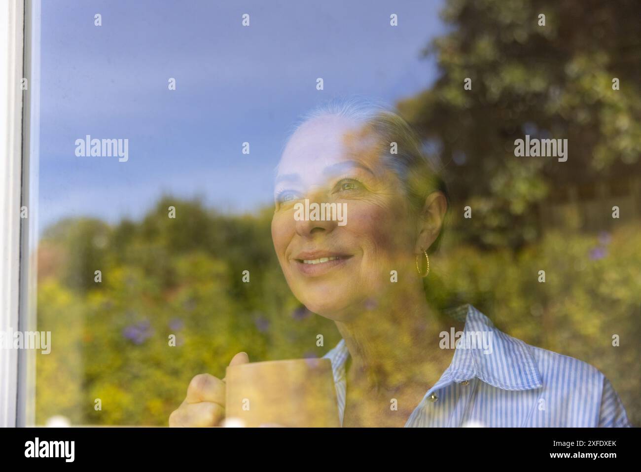 Happy mature woman by the window hi-res stock photography and images ...
