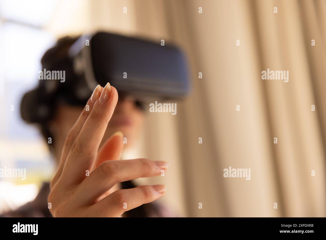 Using VR headset, woman interacting with virtual environment at home Stock Photo - Alamy