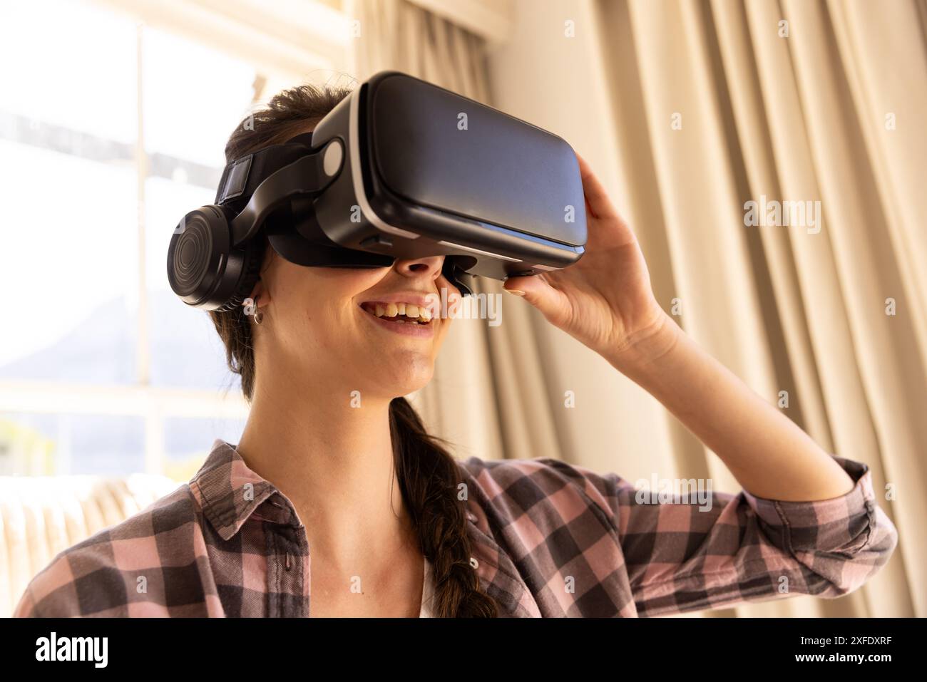 Using VR headset, young woman experiencing virtual reality at home ...