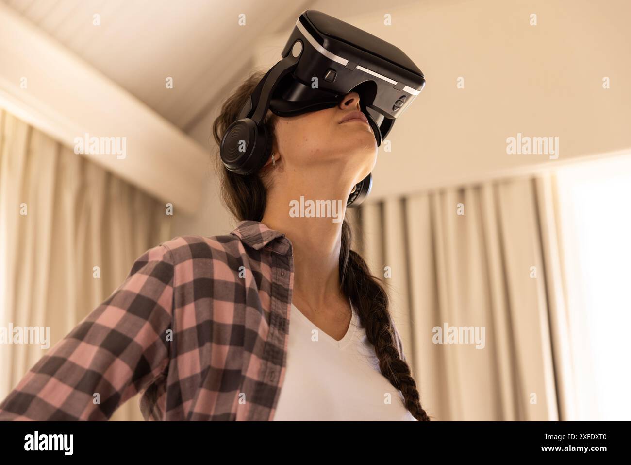 Using VR headset, woman exploring virtual reality experience at home ...