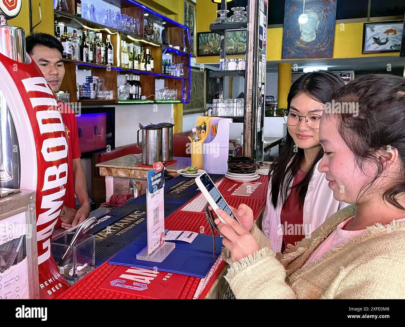 A customer uses electronic settlement to pay at a restaurant in Phnom Penh, Cambodia on June 26 ...