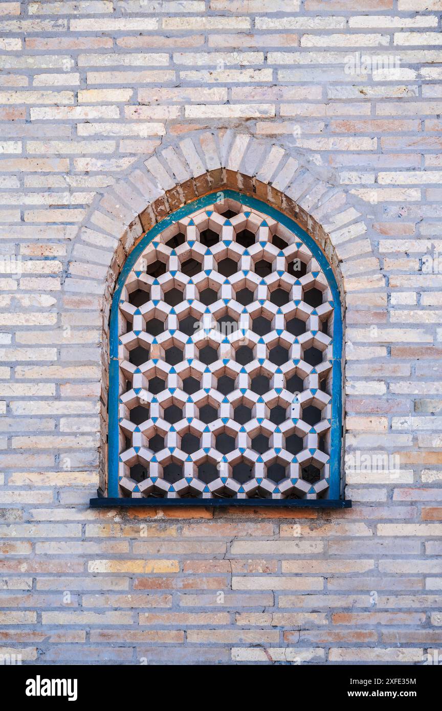 window with a lattice of ceramic tiles in the ancient brick wall of the ...