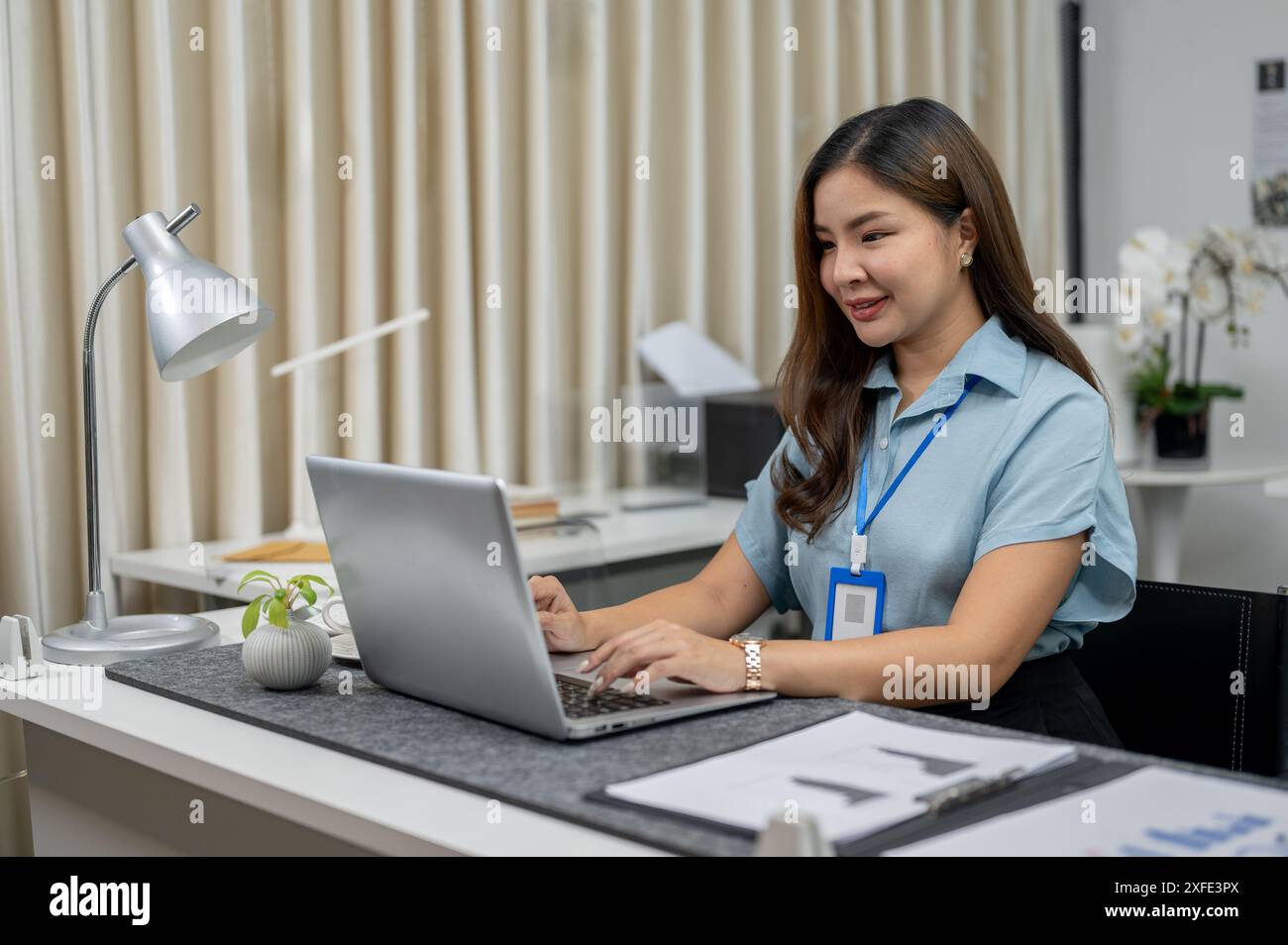 A beautiful Asian businesswoman or female assistant is working at her ...