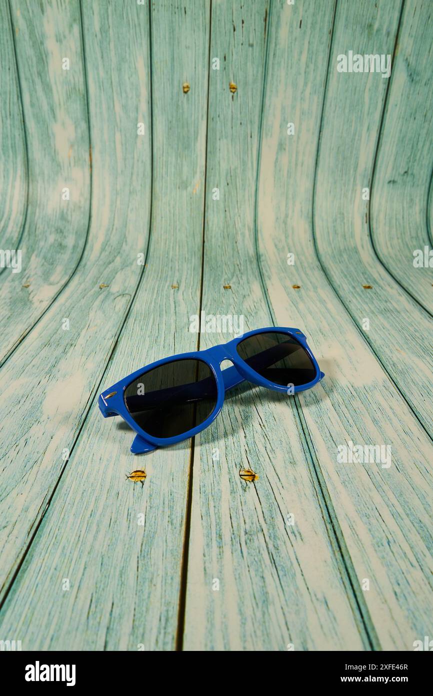 Folded sunglasses placed on wooden bench in daylight Stock Photo - Alamy