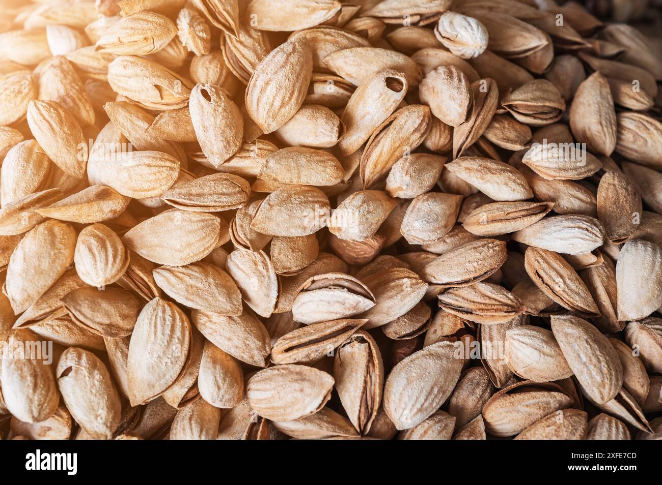 background with unpeeled almonds kernels in a shell on a market counter ...