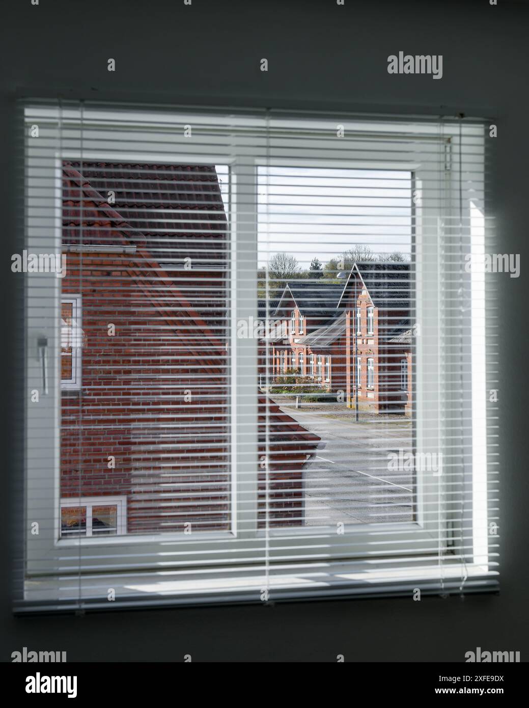 Home interior. View from the window through the blinds to the street ...