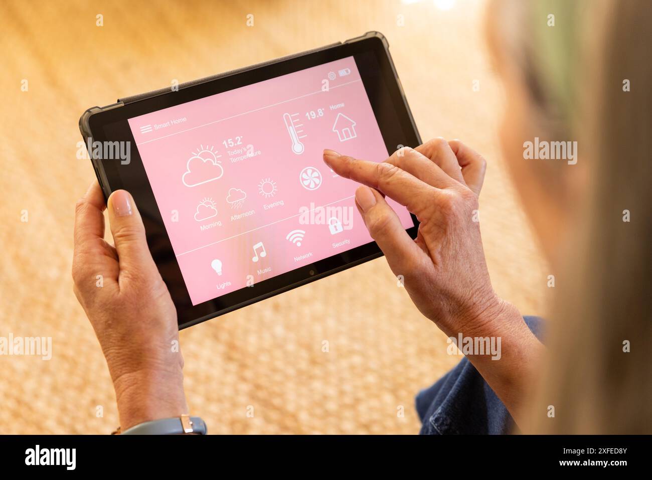 Using tablet, woman controlling smart home settings and monitoring ...