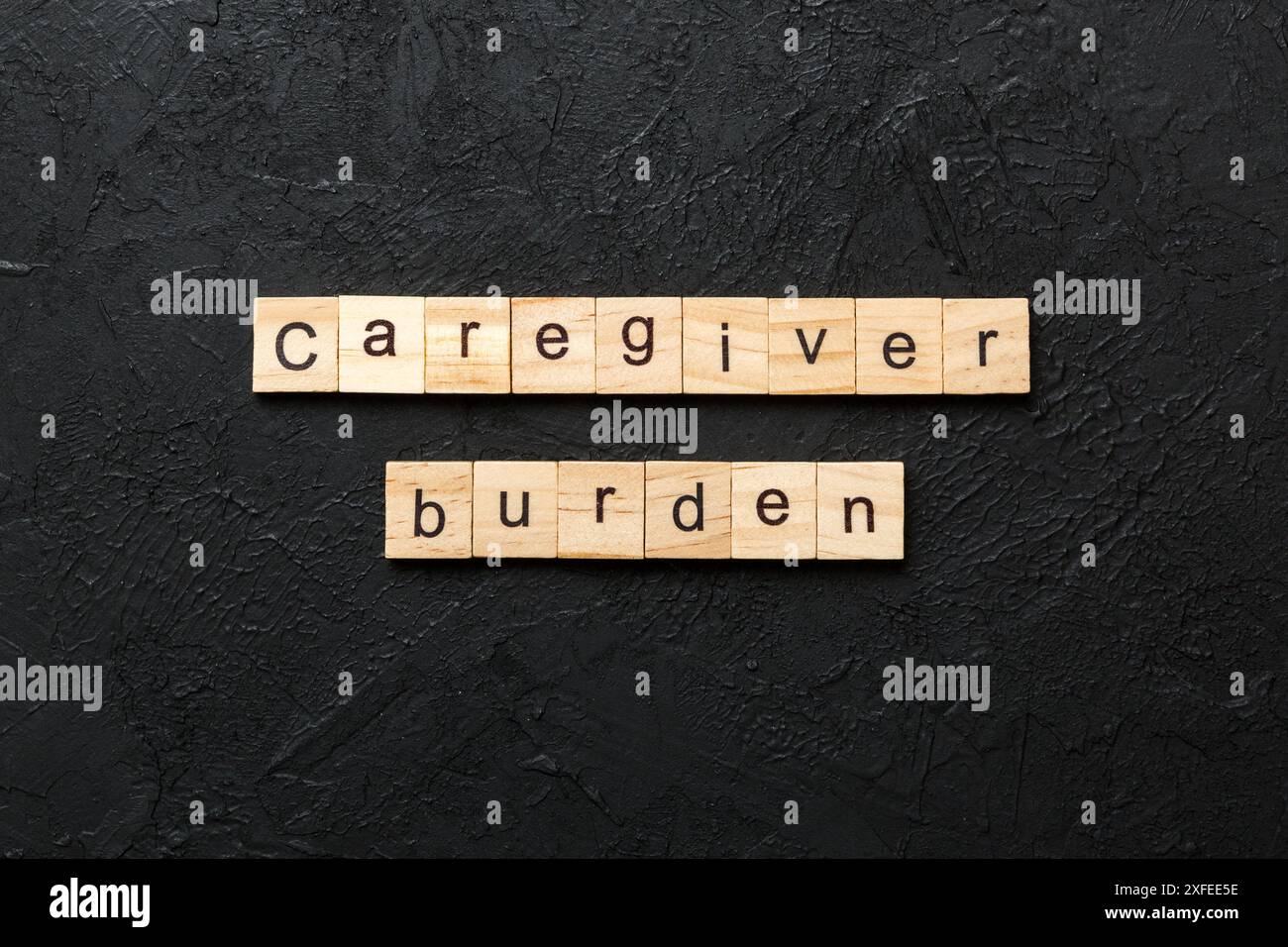 Caregiver burden word written on wood block. Caregiver burden text on ...