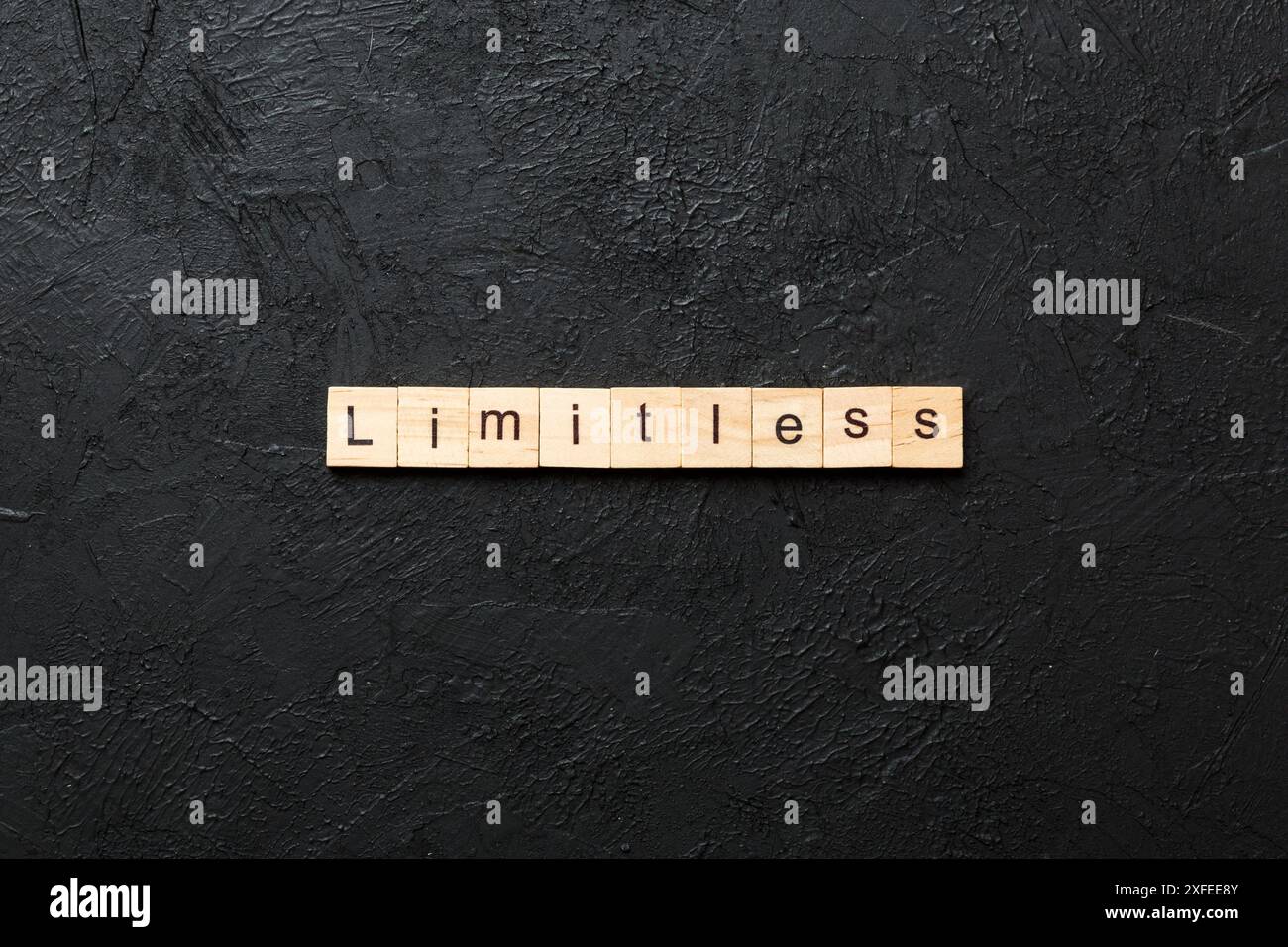 Limitless word written on wood block. Limitless text on cement table ...