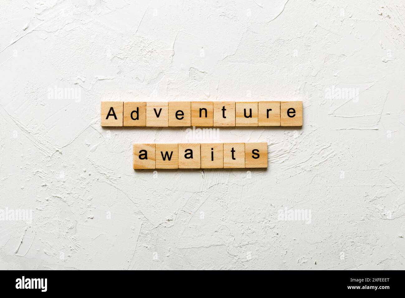 Adventure awaits word written on wood block. Adventure awaits text on ...