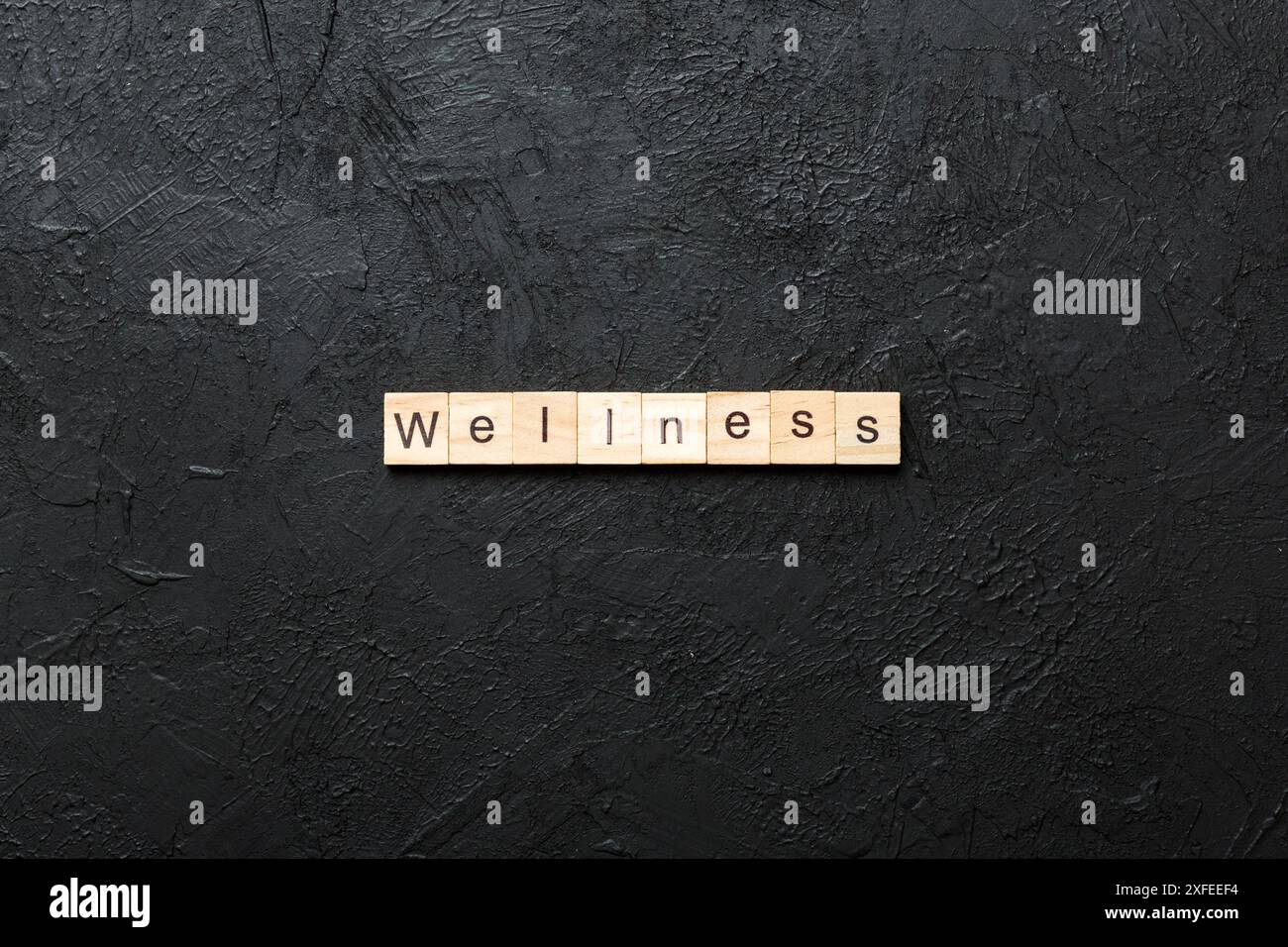 Wellness word written on wood block. Wellness text on cement table for ...