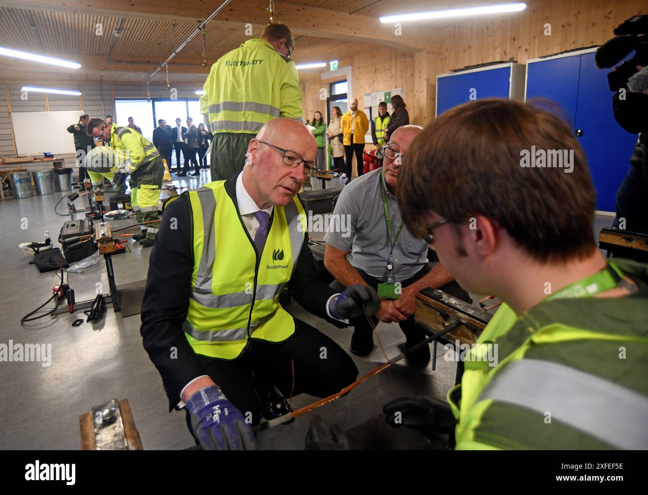 Scottish First Minister and SNP leader John Swinney speaks to a worker ...