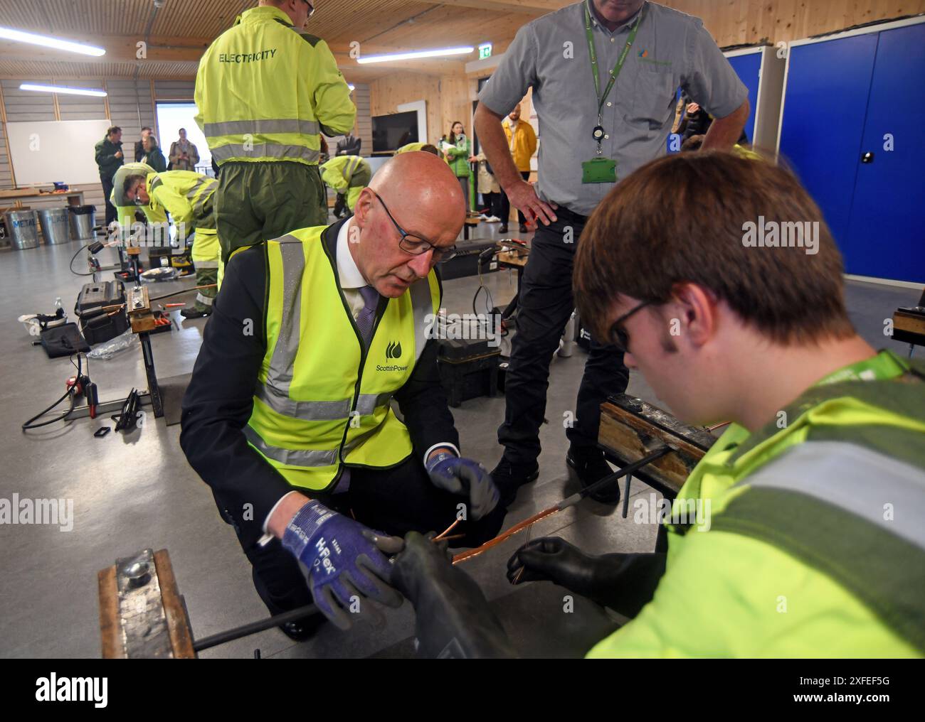 Scottish First Minister and SNP leader John Swinney speaks to a worker ...