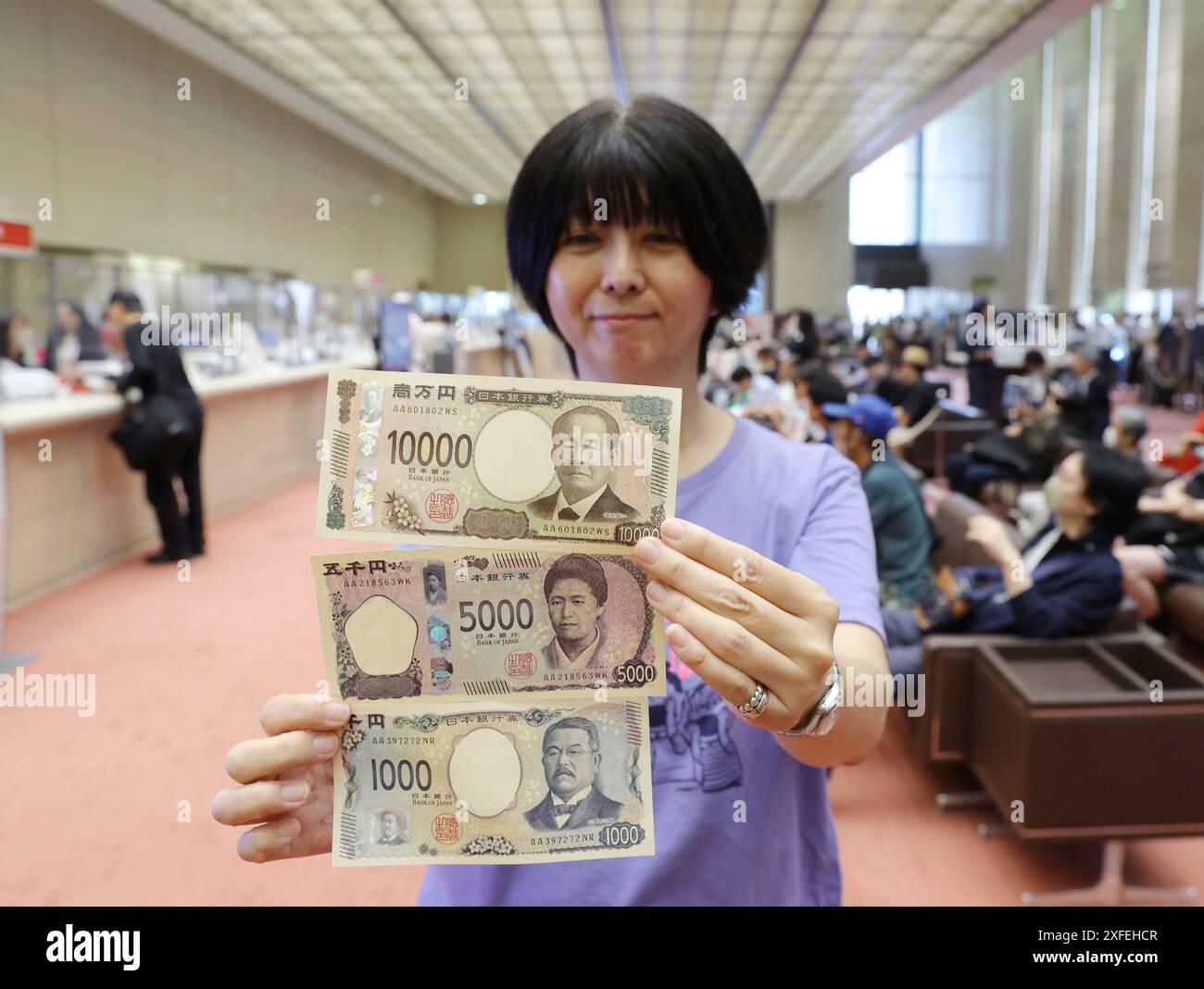 A woman shows three types of new banknotes which were issued for the ...