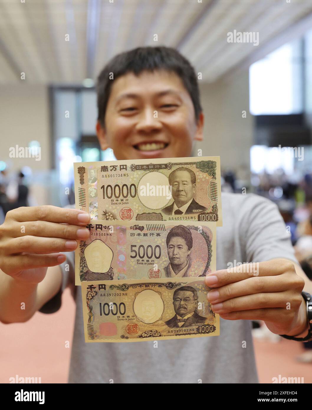 A man shows three types of new banknotes which were issued for the ...