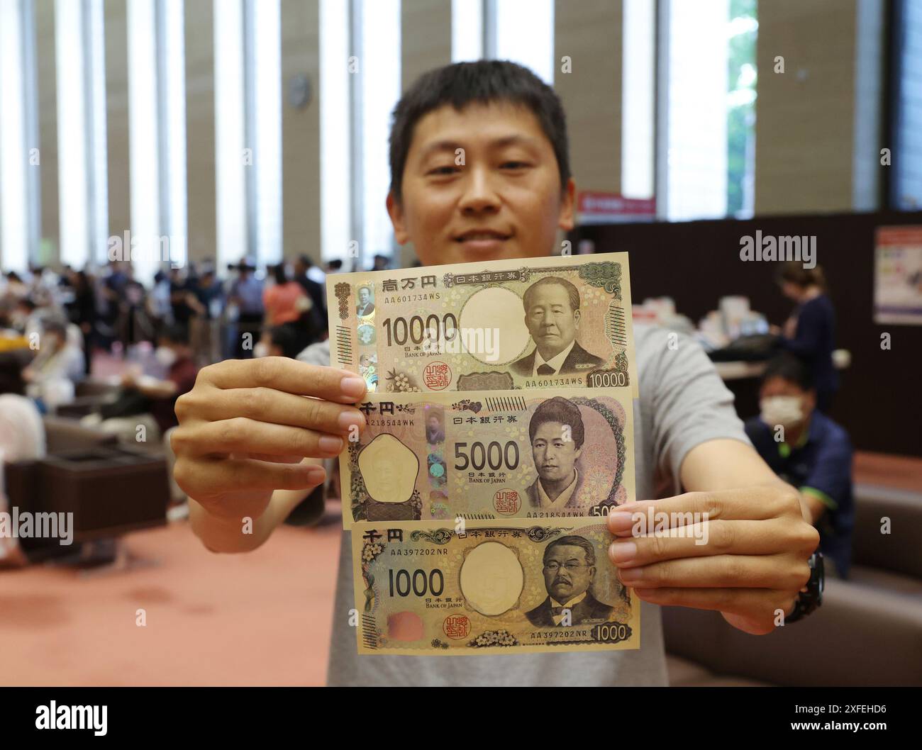A man shows three types of new banknotes which were issued for the ...