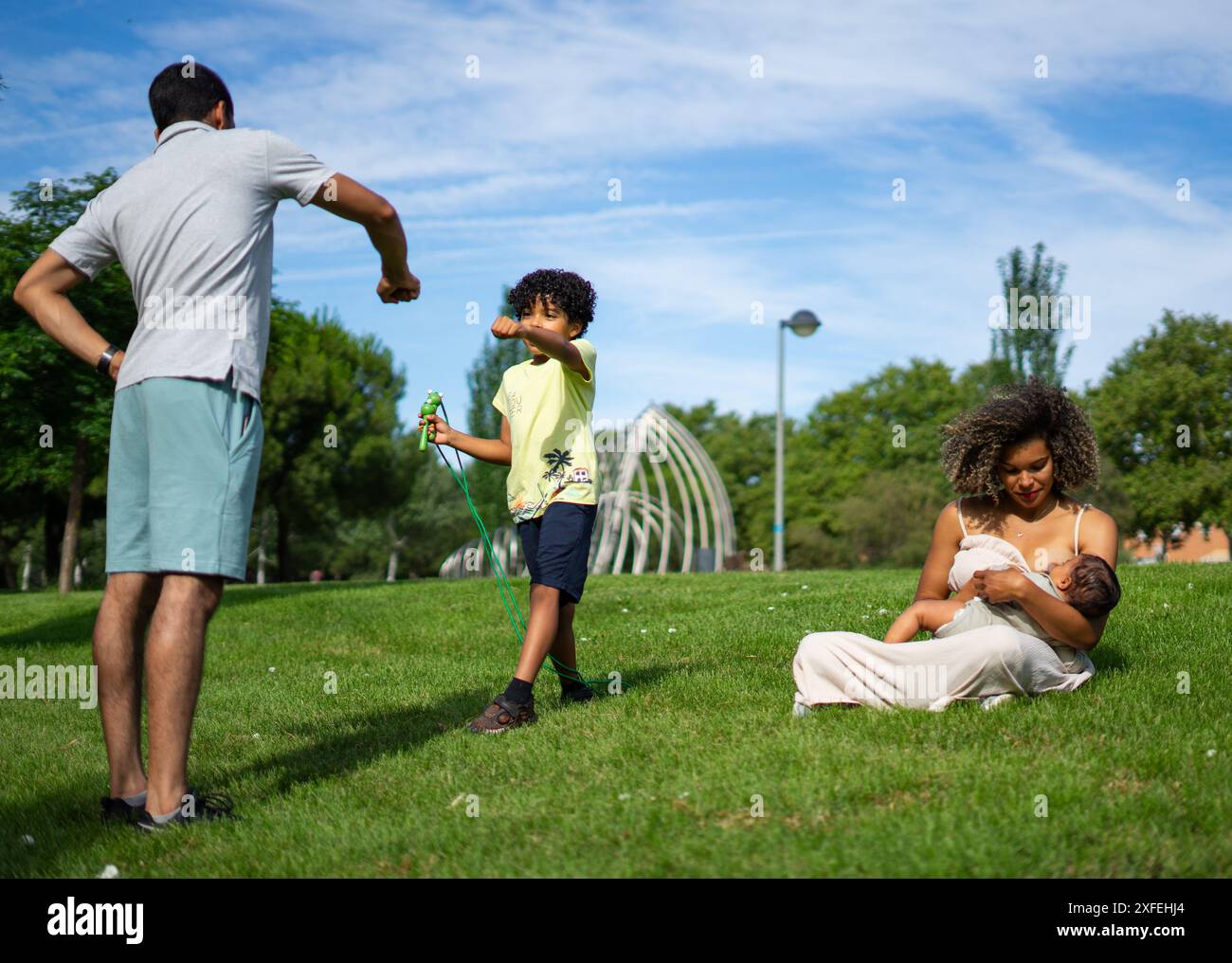 Latin family in a park, the mother breastfeeding her baby and the ...