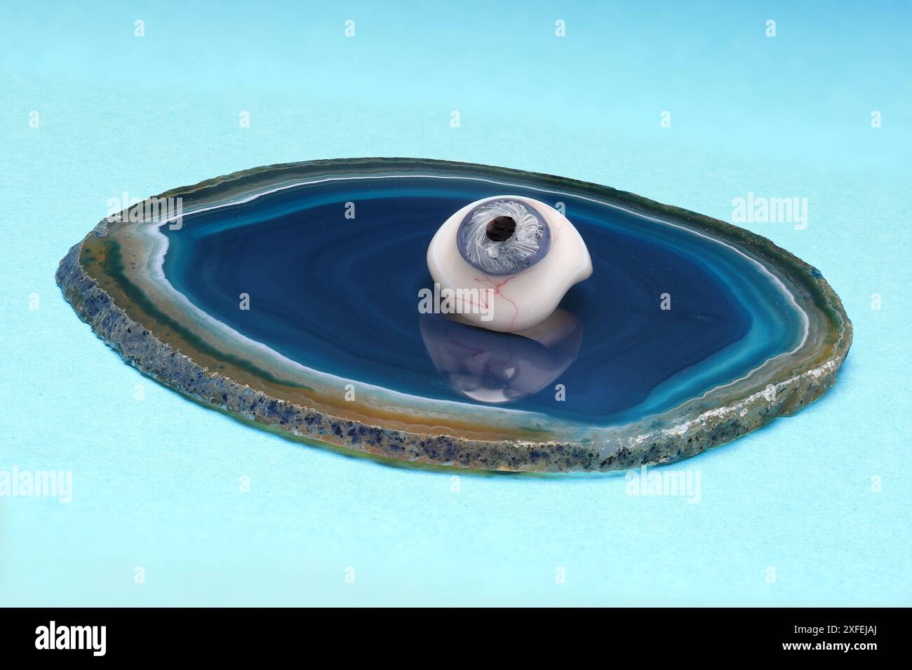 Space eye: still life agate and eye on light blue background with ...