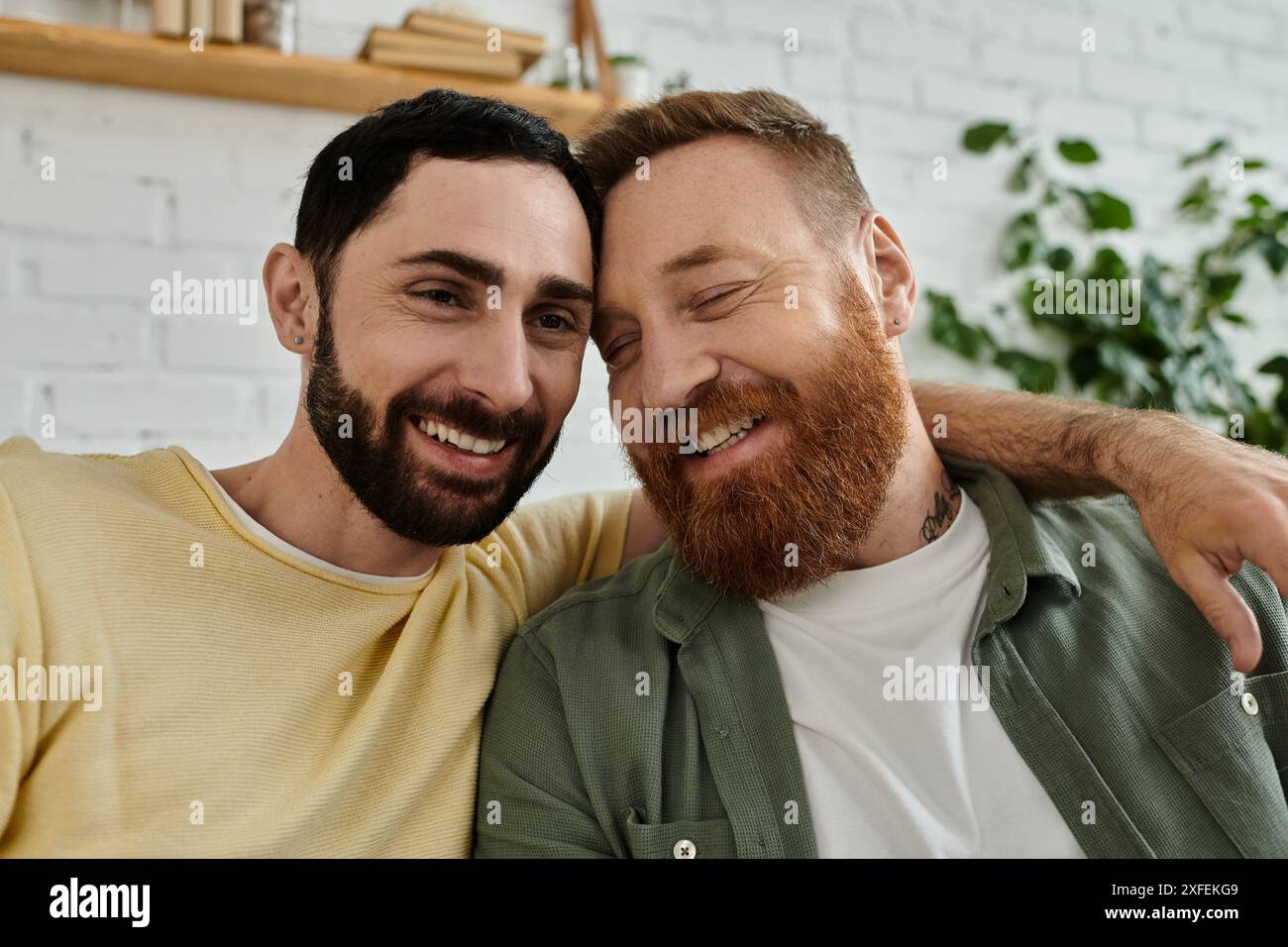 Two men, both with beards, relax on a couch and hugging at home Stock ...