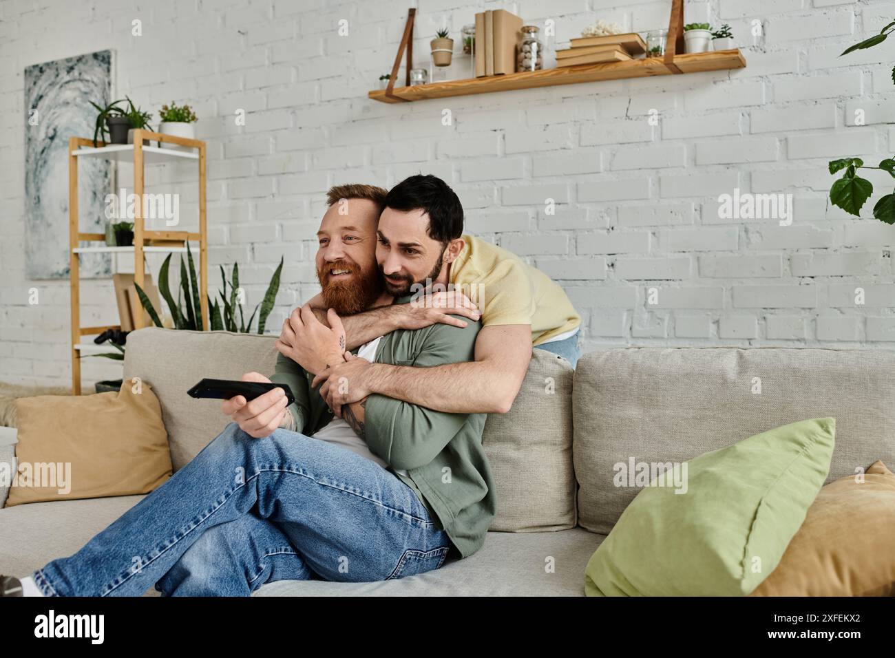 Two men with beards enjoying a cozy moment together on a couch in a ...