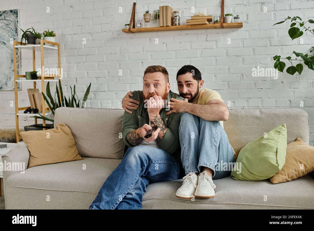 Two bearded men sitting on a couch, arms around each other, showing ...