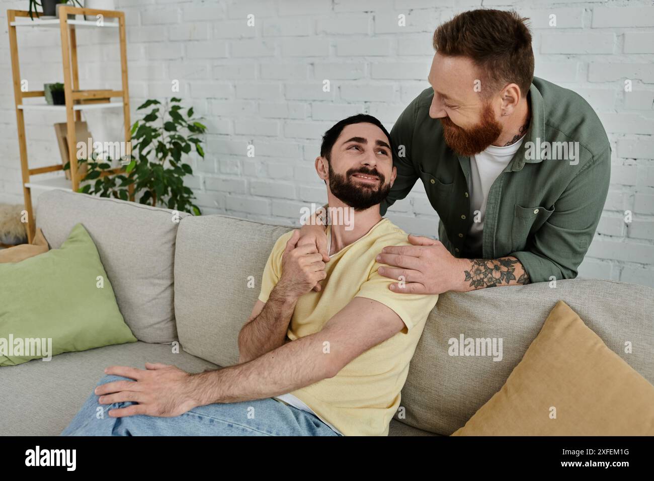 A Bearded Gay Couple Lounging Atop A Modern Couch Sharing A Cozy Moment With Their Labrador In