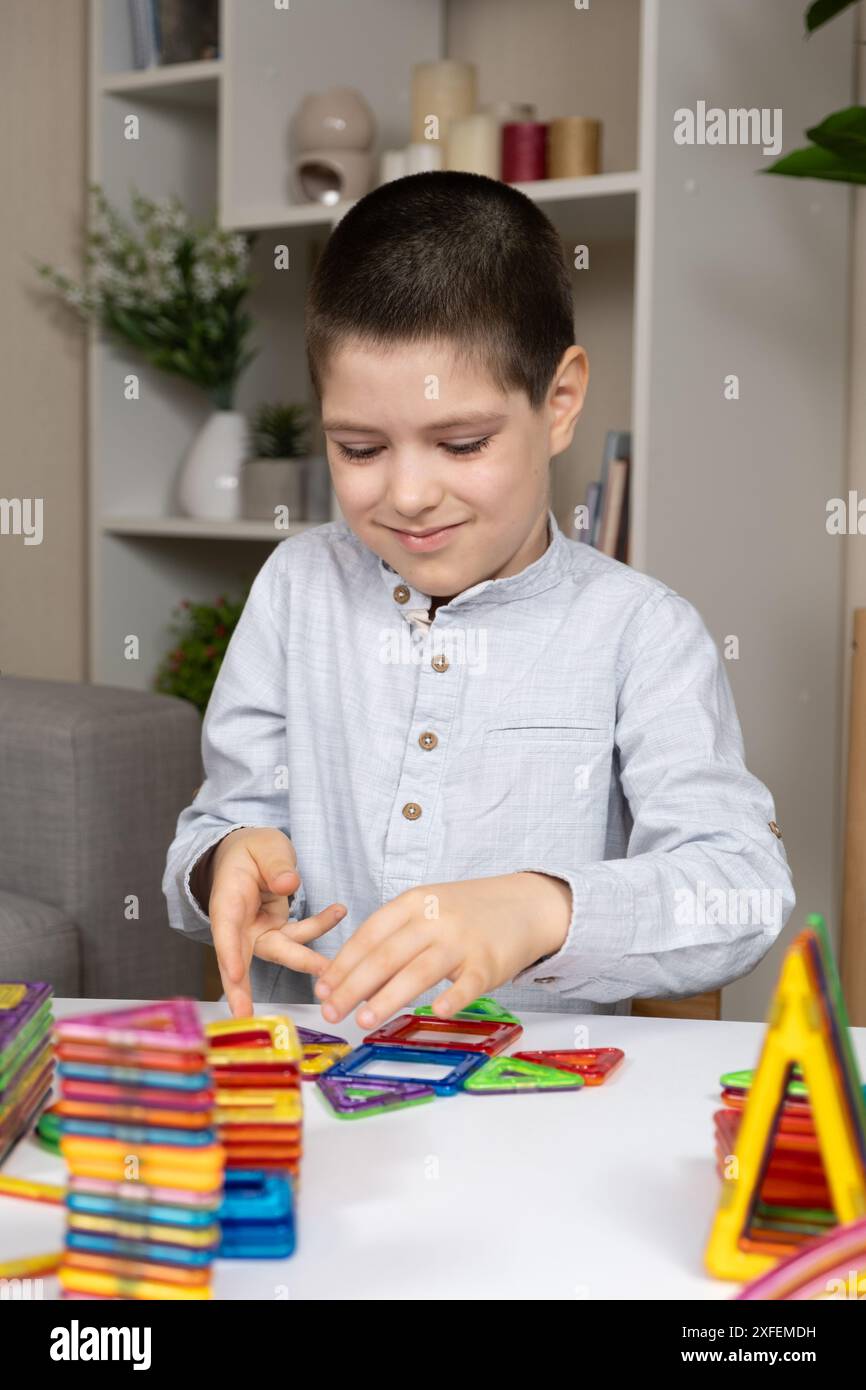 Boy builds buildings from a magnetic construction set Stock Photo - Alamy