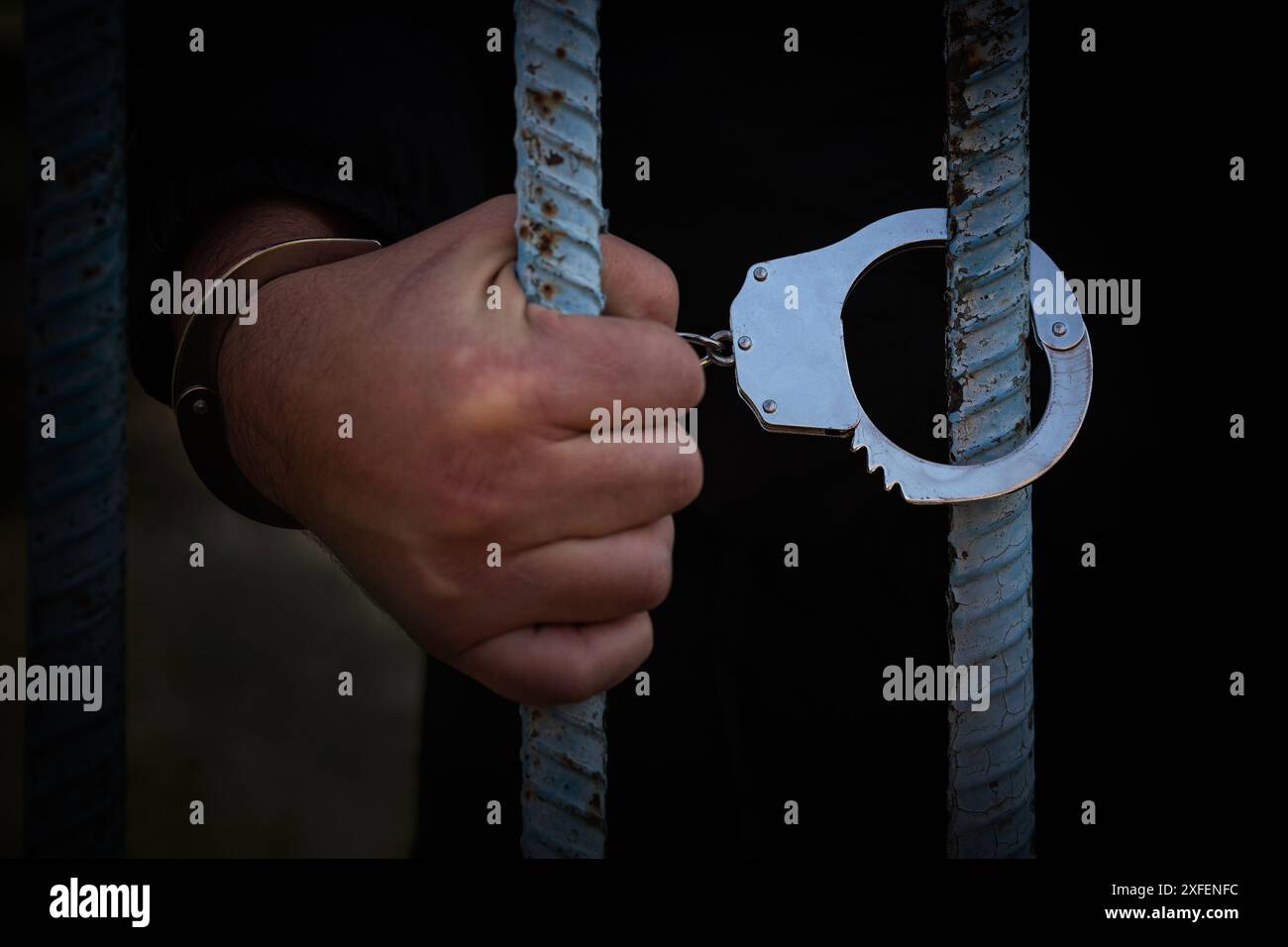 hands of prisoner with handcuff in jail as background, hands in ...