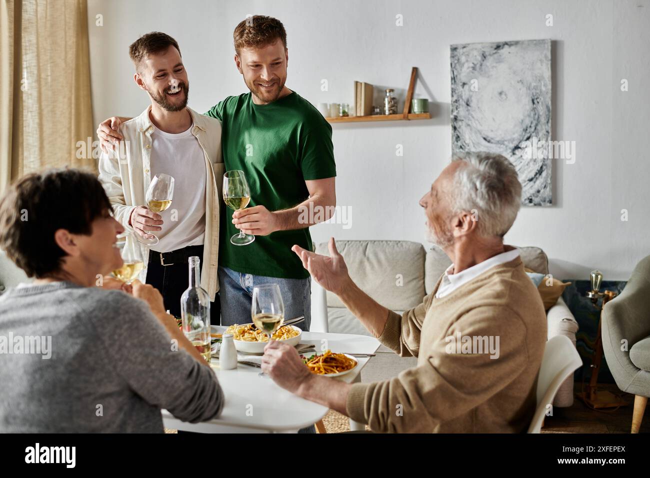 A gay couple toasts with parents during a dinner at home Stock Photo ...