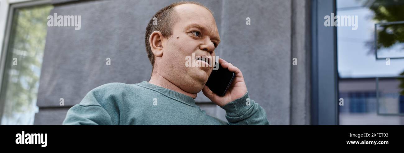 A man with inclusivity speaks on the phone outside his home Stock Photo ...
