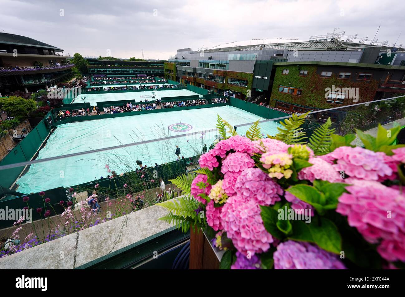 A general view of covers on the outside courts as rain delays the start ...