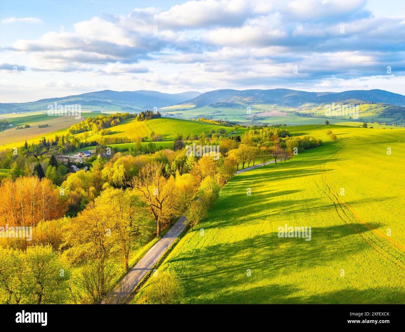 An aerial view of a winding road cutting through a rolling landscape of ...