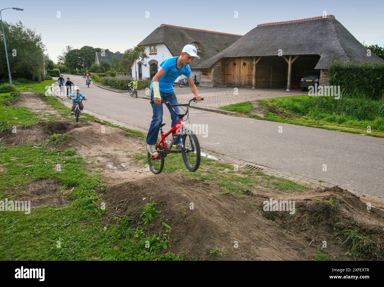 Netherlands, Loo - Children play and cycle in a car-free village street ...