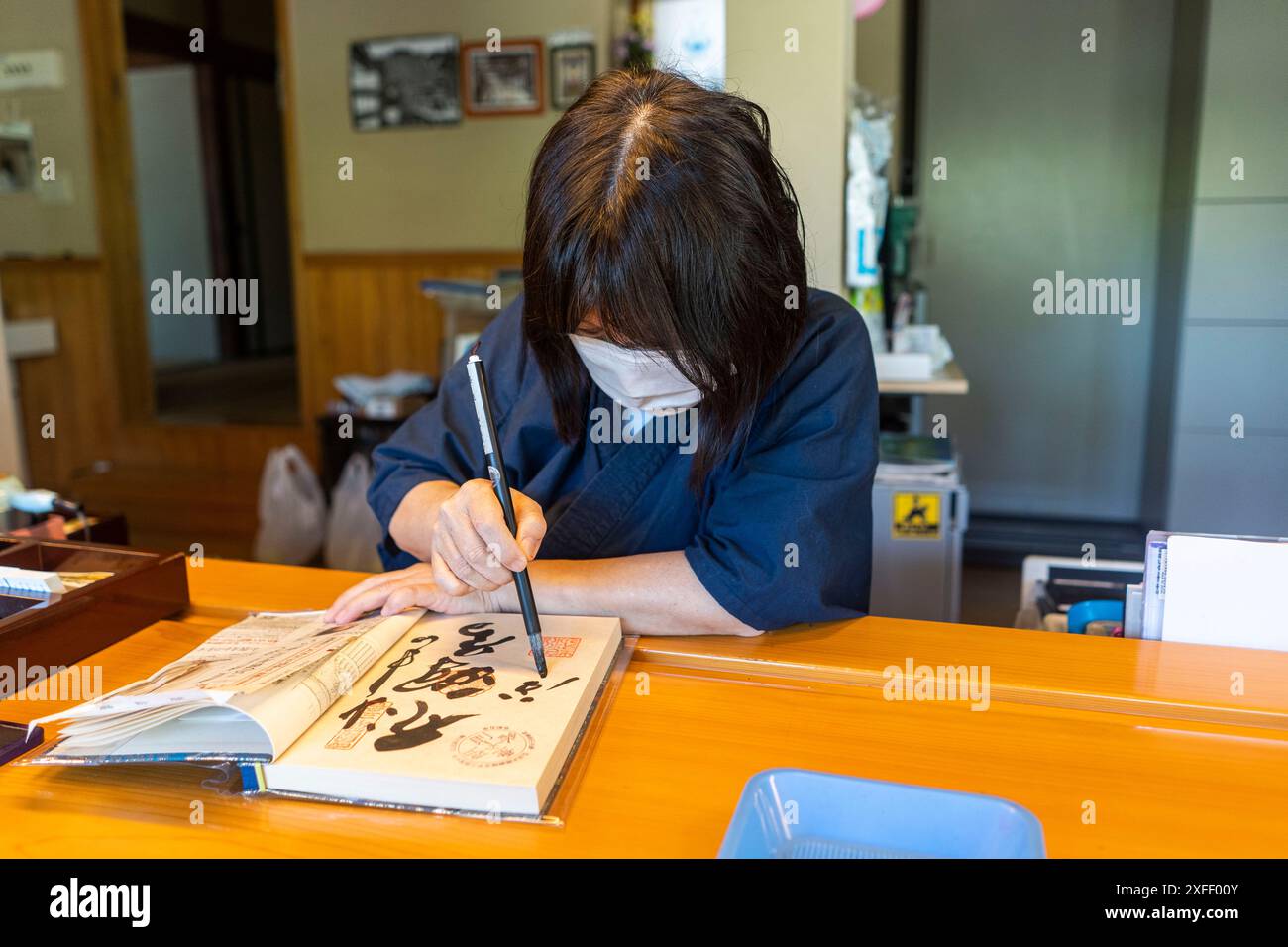 Woman writing Kanji with ink pen at Buddhist temple Stock Photo - Alamy