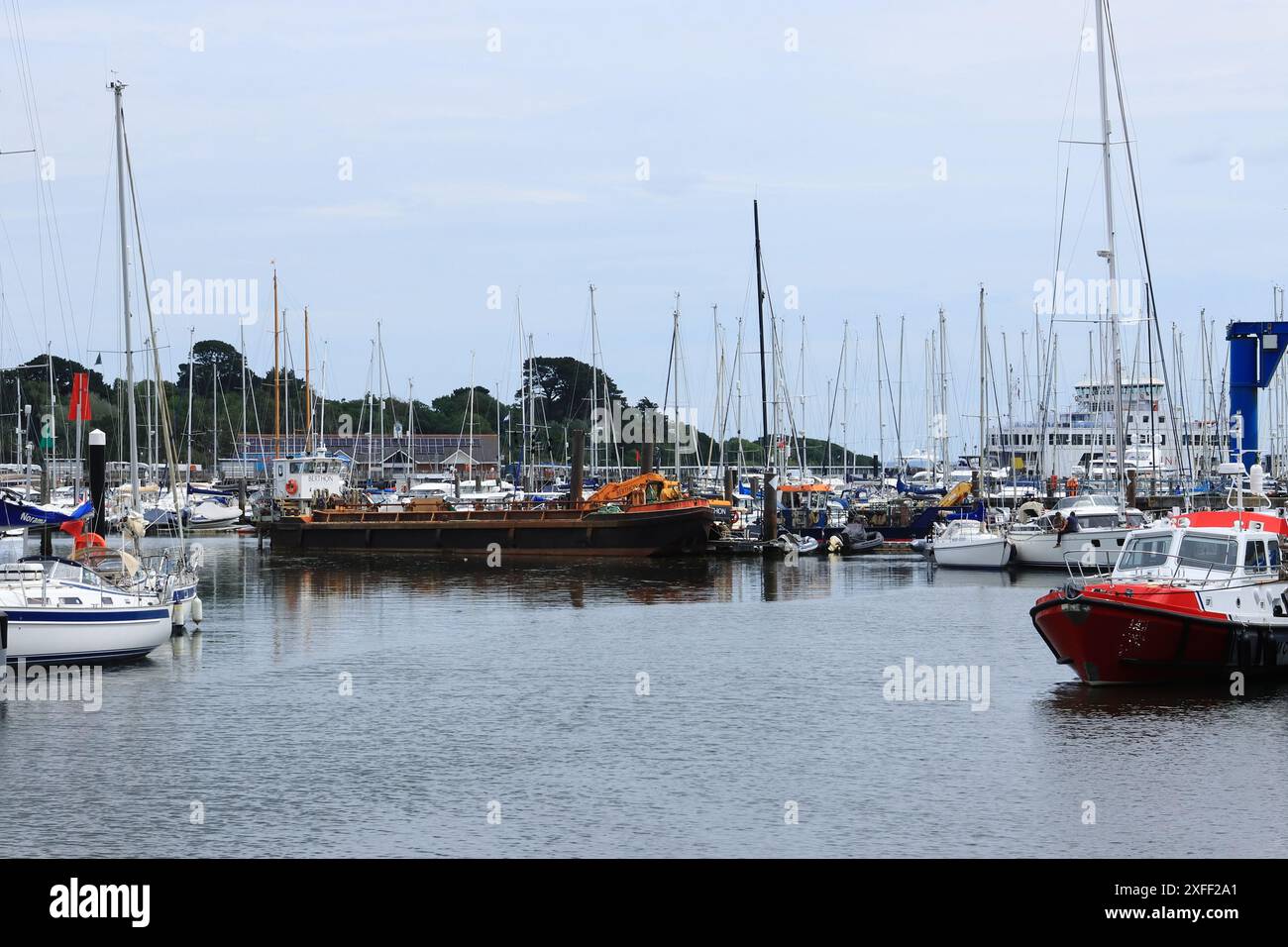 Lymington Harbour, England. 18 June 2024. Scene in the marina with a Berthon crane beside a boat ...