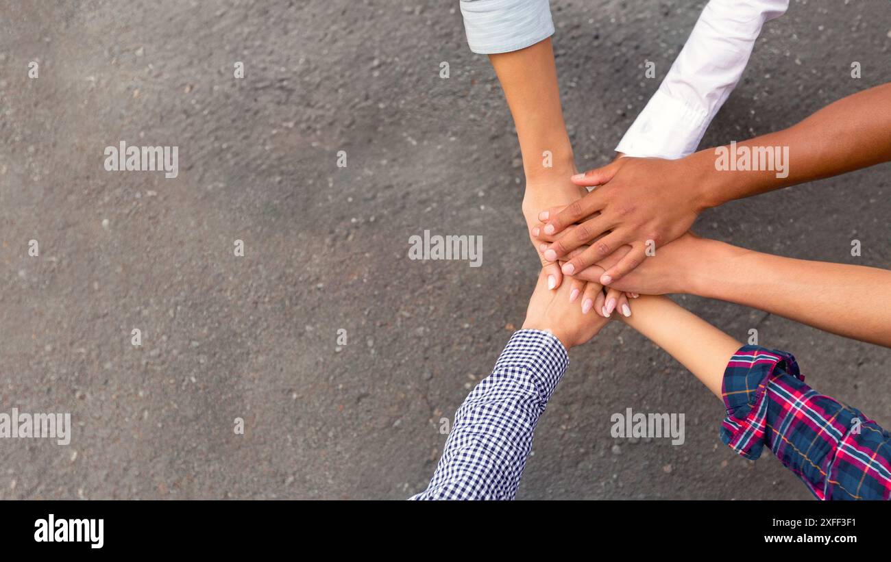 Multiracial students joining hands together in cooperation Stock Photo ...
