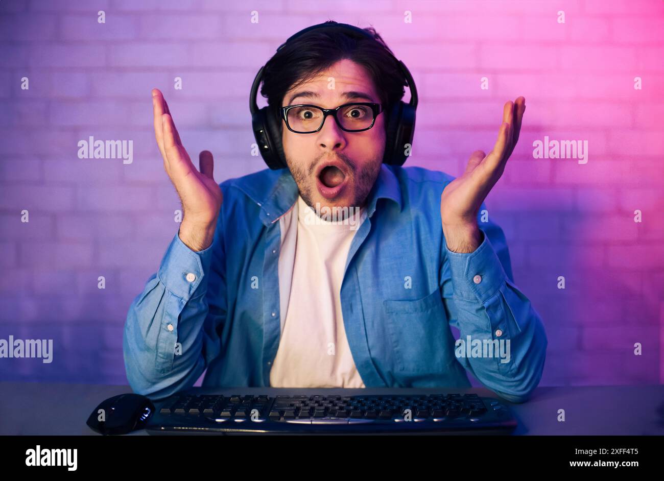 Shocked Gamer With Headphones Reacts To A Game Stock Photo - Alamy