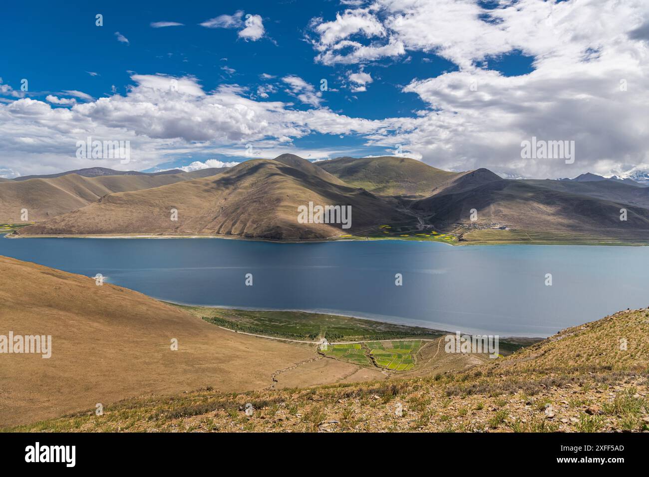 The blue water and mountains of Yamdrok Lake in Tibet, China, panoramic view with copy space for ...