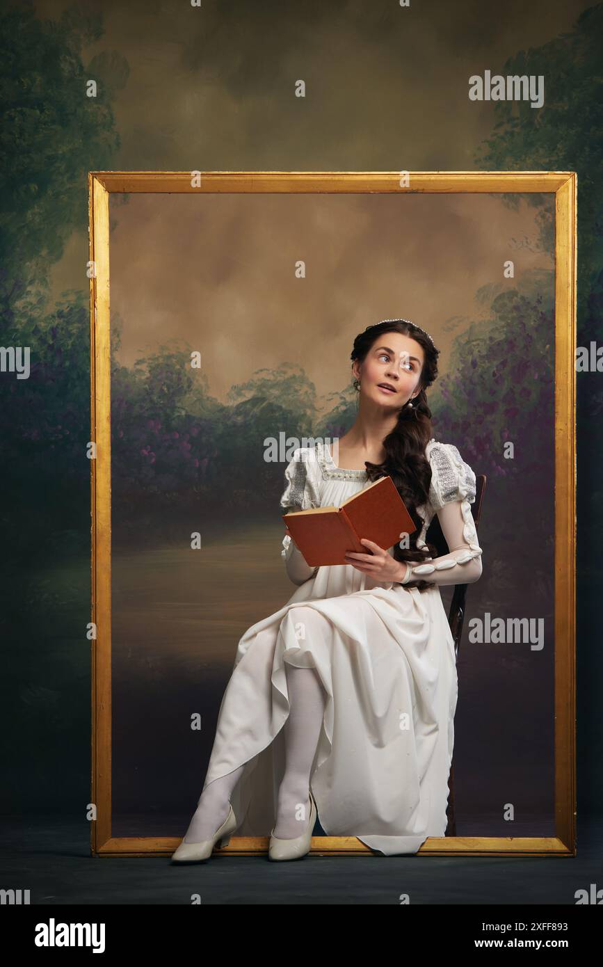 Woman in Regency-era white dress sitting in gold frame, holding open ...