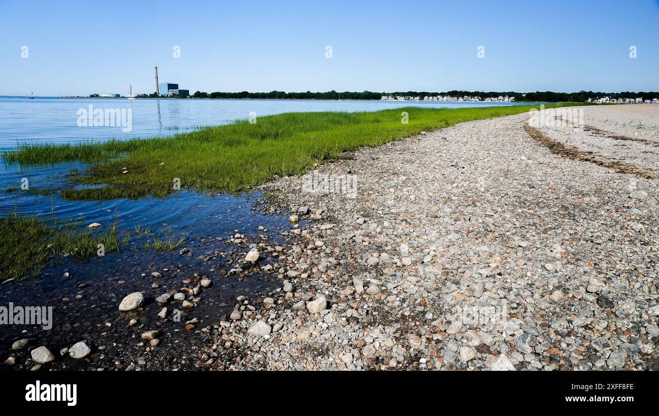 NORWALK, CT, USA - JULY 2, 2024: A rocky shoreline with a small body of ...