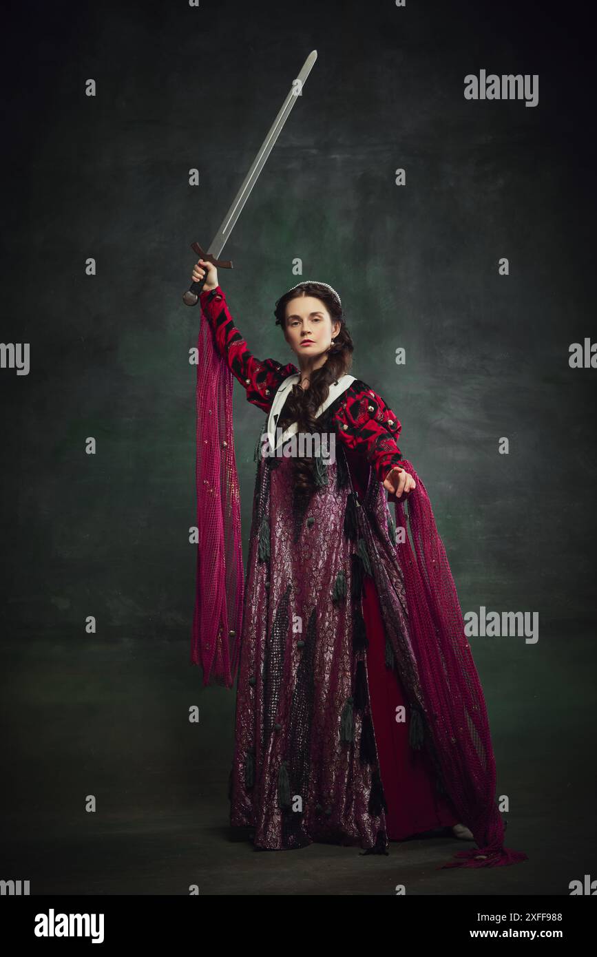 Woman in richly detailed Renaissance-style gown, holding sword aloft ...