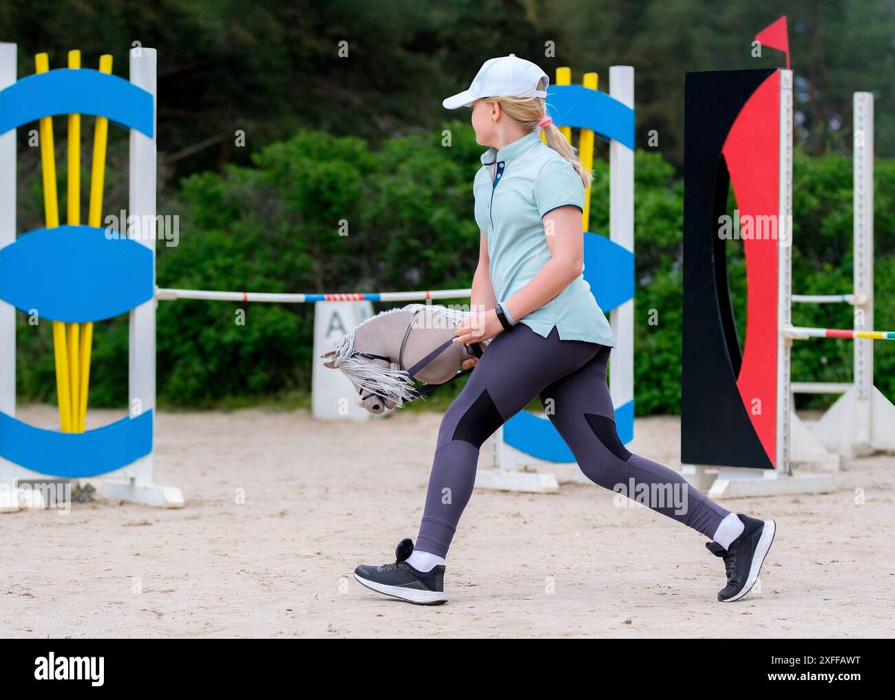 Girl jumping on hobby horse. Champion. Horse sport. Summer light. Green ...