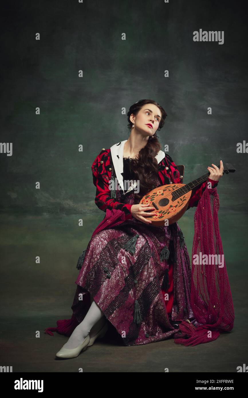 Portrait of beautiful young woman playing with a lute against vintage ...