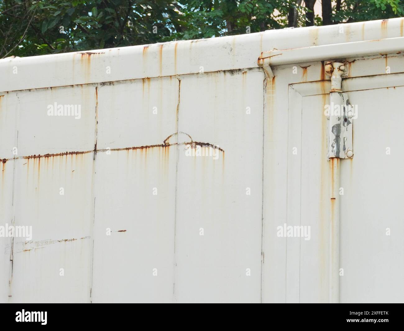 Corroded metal background. The metal wall is painted white with rust ...